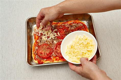 직사각형 수제 피자 피자에 강판 치즈를 손으로 넣어 위쪽 보기 가정 생활에 대한 스톡 사진 및 기타 이미지 가정 생활 가정