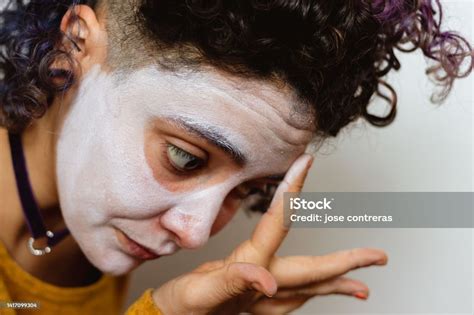 카트리나 메이크업을 위해 얼굴에 흰색 페인트를 칠하는 젊은 라틴 여성의 클로즈업 La Calavera Catrina에 대한 스톡