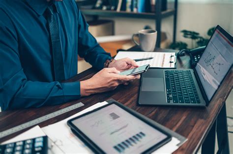 사업가는 휴대 전화를 사용하고 사무실 책상에서 작업하고 회계 금융의 새로운 프로젝트를 분석합니다 투자 재무 고문 및 회계 개념