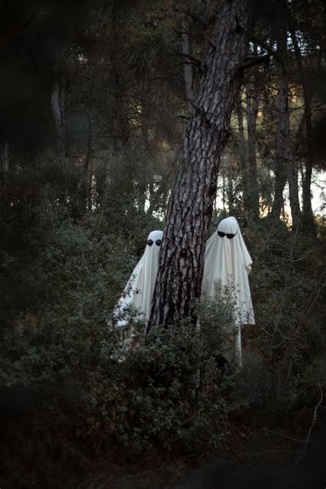 People Dressed As Ghosts Wearing Sunglasses Standing In A Forest · Free