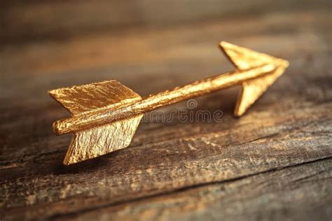 Golden Arrow On Rustic Wood Background A Golden Arrow Pointing To The Right Symbolizing