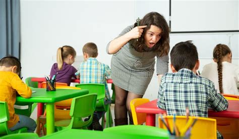 Female Teacher Scolding Guilty Student In Elementary School Class Stock