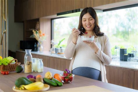 Beautiful Asian Pregnant Woman Eating With Lust Cereals On Breakfast In