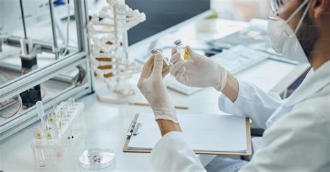 실험실 코트와 라텍스 장갑을 낀 바이러스학자가 코로나바이러스 백신을 검사하는 자른 사진 사진 Unsplash의 유리병 이미지