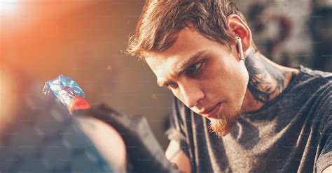 젊은 남자 문신 가게 회전식 문신 기계 검은 잉크 렌즈 플레어에서 소녀의 손에 문신을 때린다 사진 Unsplash의 문신 남자 이미지