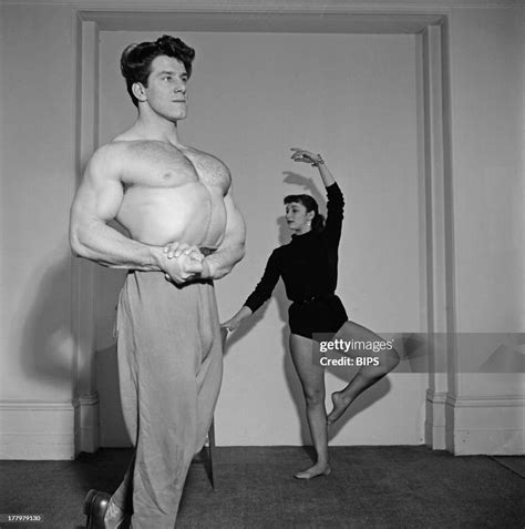 English Bodybuilder Reg Park Flexes His Muscles As His Wife South