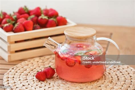딸기로 가득 찬 전체 나무 상자의 배경에 대해 테이블 위의 유리 주전자에 딸기 여름 음료 0명에 대한 스톡 사진 및 기타 이미지