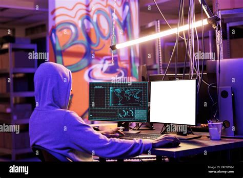 Criminal In Hood Coding Malicious Software On Computer With Empty White