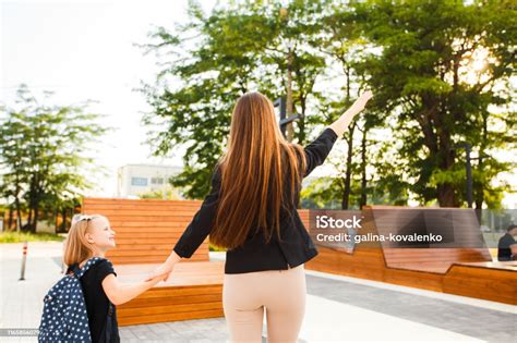 엄마는 학교에 그녀의 딸을 리드 학교로 돌아갑니다 뒷면 뒤에 배낭을 가진 여자와 여자 수업의 시작 가을의 첫날 8 9 살에 대한