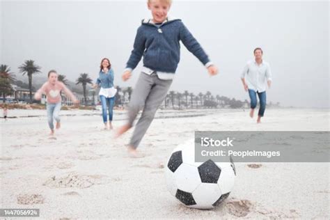 가족 축구 해변이 함께 모래 위에서 놀며 자연 속에서 스포츠와 운동을 즐길 수 있는 즐거운 시간을 보내세요 모래 바다 해안에서