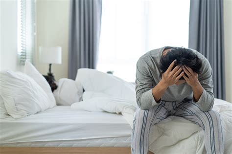 아시아 청년은 국내 에서 갈등문제를 겪고 있는 여자친구에게 화가 난다고 느낍니다 새로운 결혼 남자와 여자는 침실에서 침대에 앉아