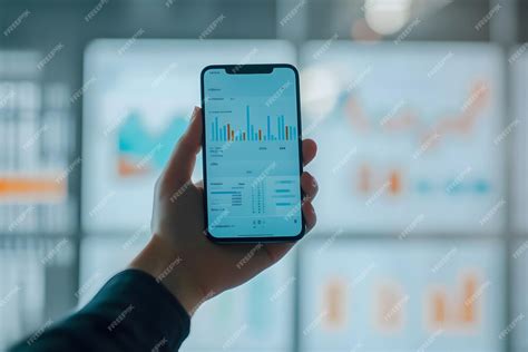 Hand Holding A Smartphone With Data Analysis Charts And Graphs