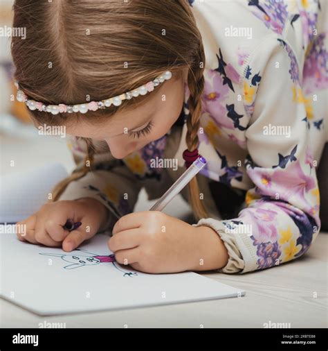 Girl Immersed In Drawing Creating Imaginary Beings Lying On Her
