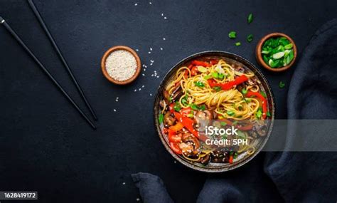세라믹 그릇에 붉은 파프리카 샴 피뇽 파 참깨 등 야채와 함께 볶은 국수 검은색 테이블 배경 평면도 파스타에 대한 스톡 사진 및