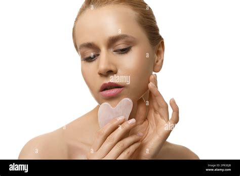 Beautiful Young Woman Doing Facial Massage With Gua Sha Tool On White