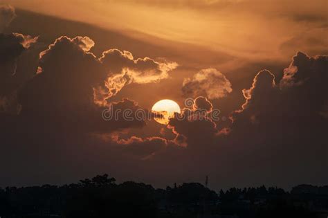 Sun Disk Peeks Out From Behind Dramatic Backlit Clouds Stock
