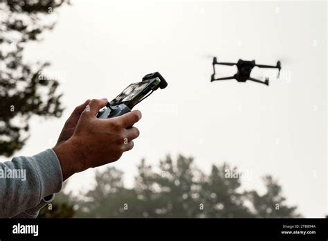 Photograph Of Mans Hands Holding The Remote Control Of A Drone Drone