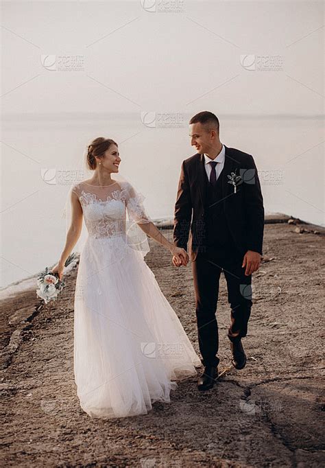 幸福的新婚夫妇在美丽的日落娱乐