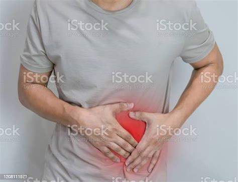 배 꼽에 통증과 부상을 보여주기 위해 허리 둘레에 두 손바닥으로 복통으로 고통받는 남자 건강관리와 의술에 대한 스톡 사진 및