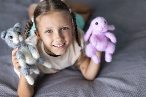 Uma Menina De Oito Anos Brinca Com Brinquedos De Malha Foto De Stock