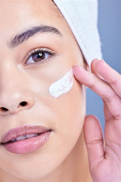 Closeup Portrait Of A Beautiful Young Mixed Race Woman Applying Cream