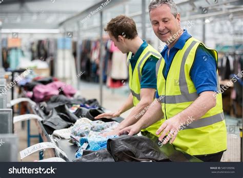 Two Men Sorting Clothes On Conveyor Stock Photo Shutterstock