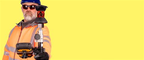 파란색 헬멧 주황색 반사 하이 가시성 양털 및 흰색 배경에 안전 장갑을 착용하고 현대적인 측량 장비를 사용하여 텍스트를위한 공간을 갖춘 건축업자 흰색 배경에 격리 된 최신