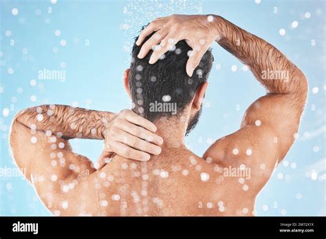 Face Back And Water Splash Of Man In Shower In Studio On A Blue