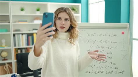 Young Blonde Woman Teacher Having Video Call Explaining Maths Exercise