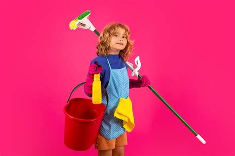 어린이 청소 개념 성장 개발 가족 관계 가사 및 가정 청소 개념의 초상화 스튜디오 격리 된 배경 청소를 위해 어린이 사용 살포기와 장갑 프리미엄 사진