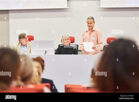 Male And Female Speakers At Conference Taking Questions From People In