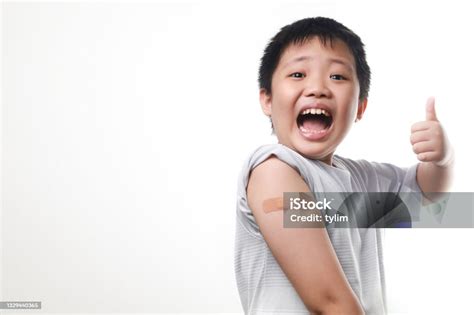 행복한 아시아 소년의 초상화는 백신을 받은 후 밴드 원조로 어깨를 드러내며 예방 접종을 받습니다 백신접종에 대한 스톡 사진 및