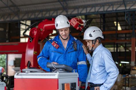 caucasian male holding remote control a robot arm machine talking with