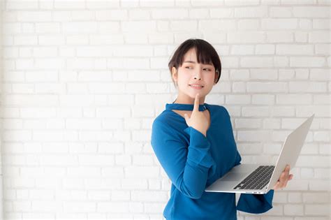 아름 다운 아시아 젊은 여성 소식통 시멘트 콘크리트 배경 여자 의심과 컴퓨터 인터넷 온라인 프리랜서 및 비즈니스 개념에 대 한
