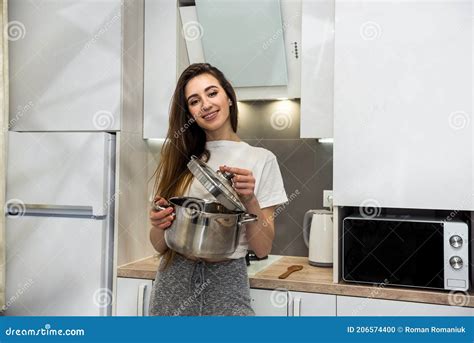 Mujer Joven Cocinando Comida En Una Olla En La Cocina Foto De Archivo