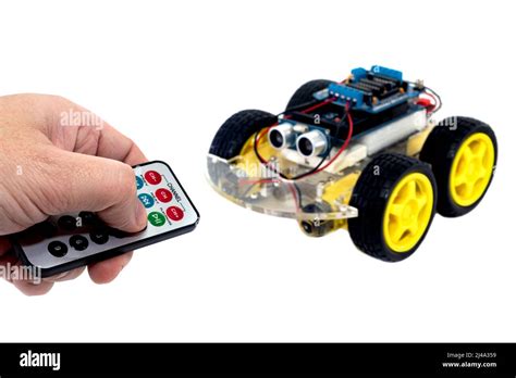 Hands Using A Wireless Remote Turn On A Programmable Robotic Car With