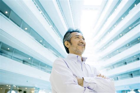 东方人一个人商店站笑双手交叉微笑露齿笑横图室外白天仰视衬衫购物消费超市商场照明亚洲仅一个男性仅一个人