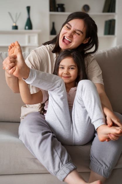 Plano completo madre haciendo cosquillas en los pies del niño Foto Gratis