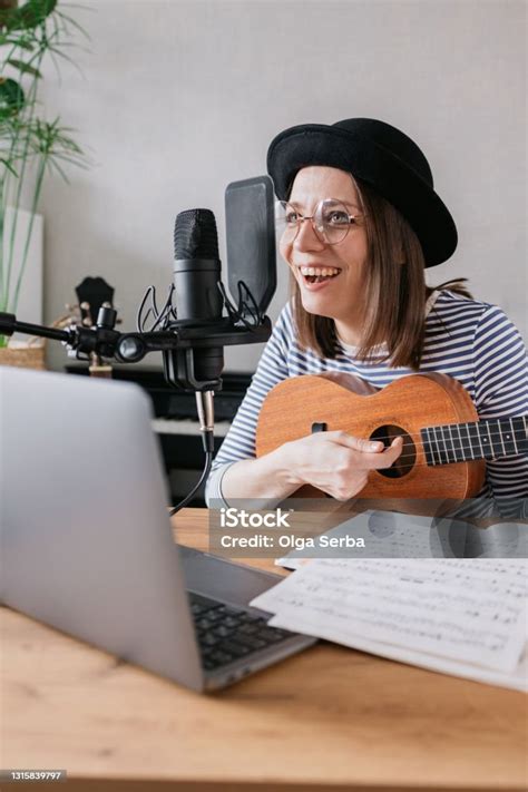 팟캐스트 음악 오디오 콘텐츠 제작 기타 또는 우쿨렐레와 모자를 쓴 아름다운 유럽 여성 팟캐스터 녹음 스튜디오에서 팟캐스트 또는 콘텐츠 노래 및 음악을 녹음하는 라디오 호스트