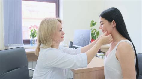 A Female Doctor Examines The Patient S Throat In The Office Stock