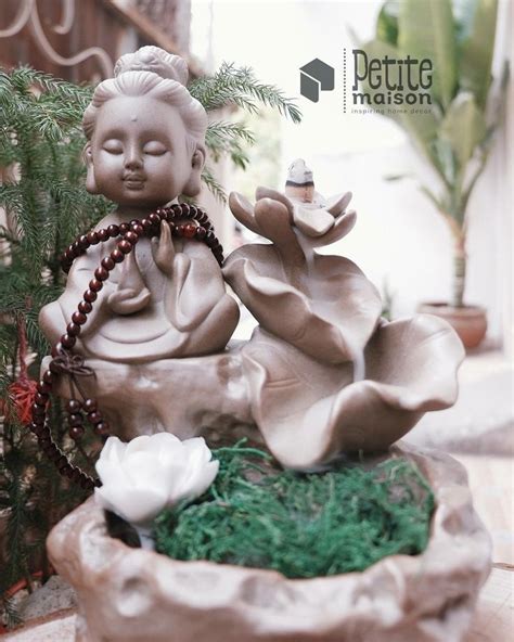 A Buddha Statue Sitting On Top Of A Planter