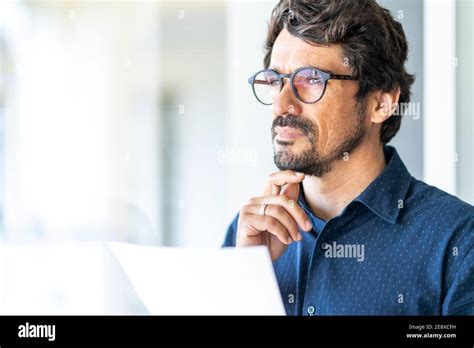 Business Man Wearing Glasses Holding Paper Document Looking At The