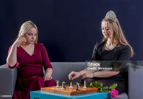 두 젊고 귀여운 여자는 체스를 재생합니다 어두운 배경에 소파에 앉아 2명에 대한 스톡 사진 및 기타 이미지 2명 검은색 게임의 밤 레저 활동 Istock