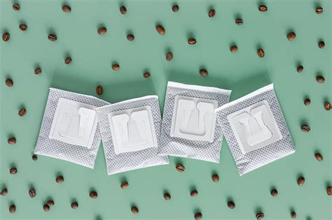 컵과 산란 커피 콩에 양조를위한 분쇄 커피 가방 종이 가방 드립 커피 필터 민트 색상 배경 상단 보기 복사 공간이있는 최소한의 평평한 평지로 포장 0명에 대한 스톡 사진 및