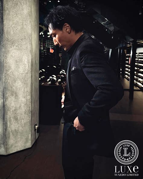 Luxe Tuxedo｜tailor Made And Rental 徐偉棟以黑色暗花圖案西裝出席香港電影金像獎，內搭黑色恤衫及馬甲，再配以銀色袋巾點綴，黑與銀為造型增添層次，穩重大方。燈光