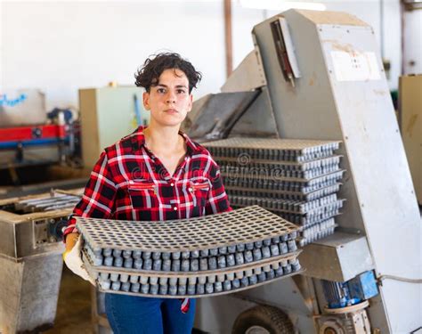 portrait of female farm worker loading boxes with vegetable seeds in