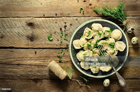 전통적인 러시아어 Pelmeni 라비 올 리 밀가루 파 슬 리 메 추 라 기 계란 후추 로즈마리 베이 리프와 향신료와 함께 나무
