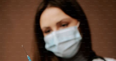 흰 코트와 파란 장갑을 낀 여자가 Sy를 들고 있다 사진 Unsplash의 주사 이미지