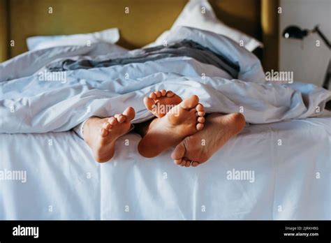 Crop Anonymous Barefoot Wife And Husband Cuddling Feet While Sleeping