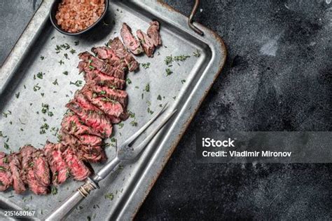 Bbq 로스트 슬라이스 스커트 쇠고기 고기 스테이크를 백리향과 함께 강철 트레이에 담았습니다 검은색 배경입니다 평면도 공간 복사